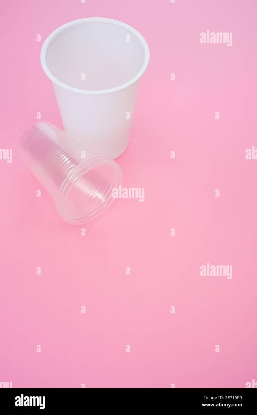 Vertical shot of big and small plastic cups on a pink surface Stock ...