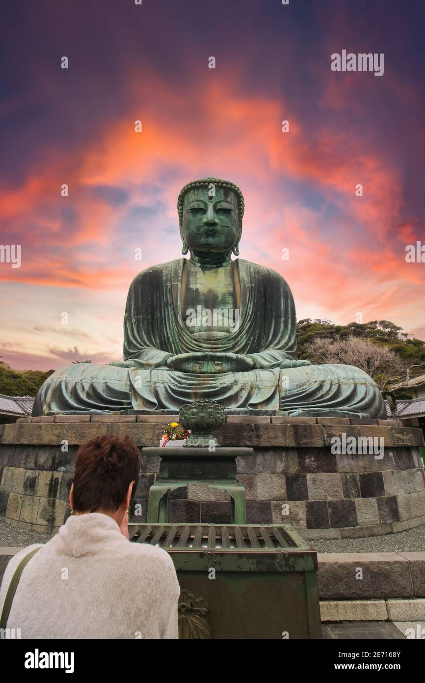 Woman praying and wishing at The Great Buddha at Kamakura, Japan at ...