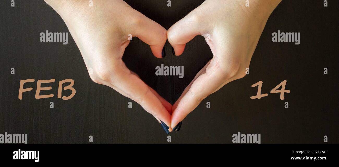 February 14 valentines day symbol. Woman making heart shape on dark ...