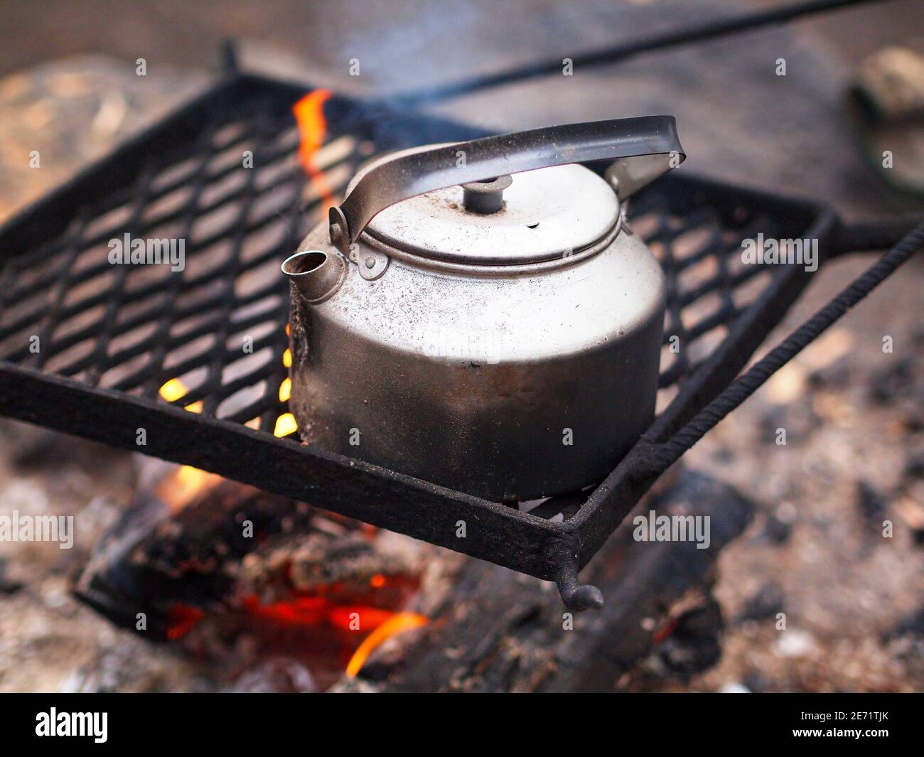 Campfire teapot over the fire, making coffee and tea at the campsit ...