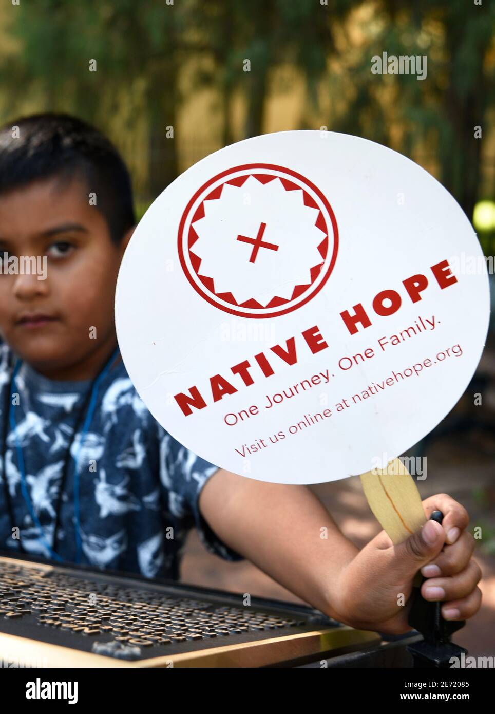 A young Native-American boy holds a fan distributed by the Native Hope ...