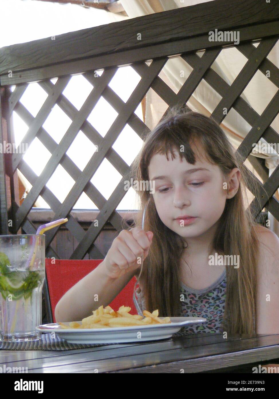 happy little girl eating a french fries. Girl eating french fries. Fast ...