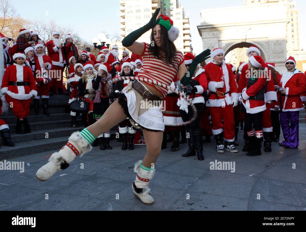 A woman dressed as an elf uses a hula hoop at Santacon, an annual Santa ...