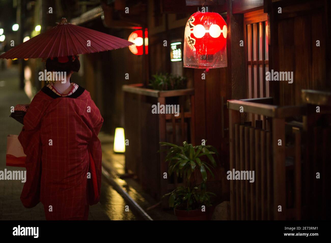 Geisha walking with umbrella enroute to a job on a rainy night in Kyoto ...
