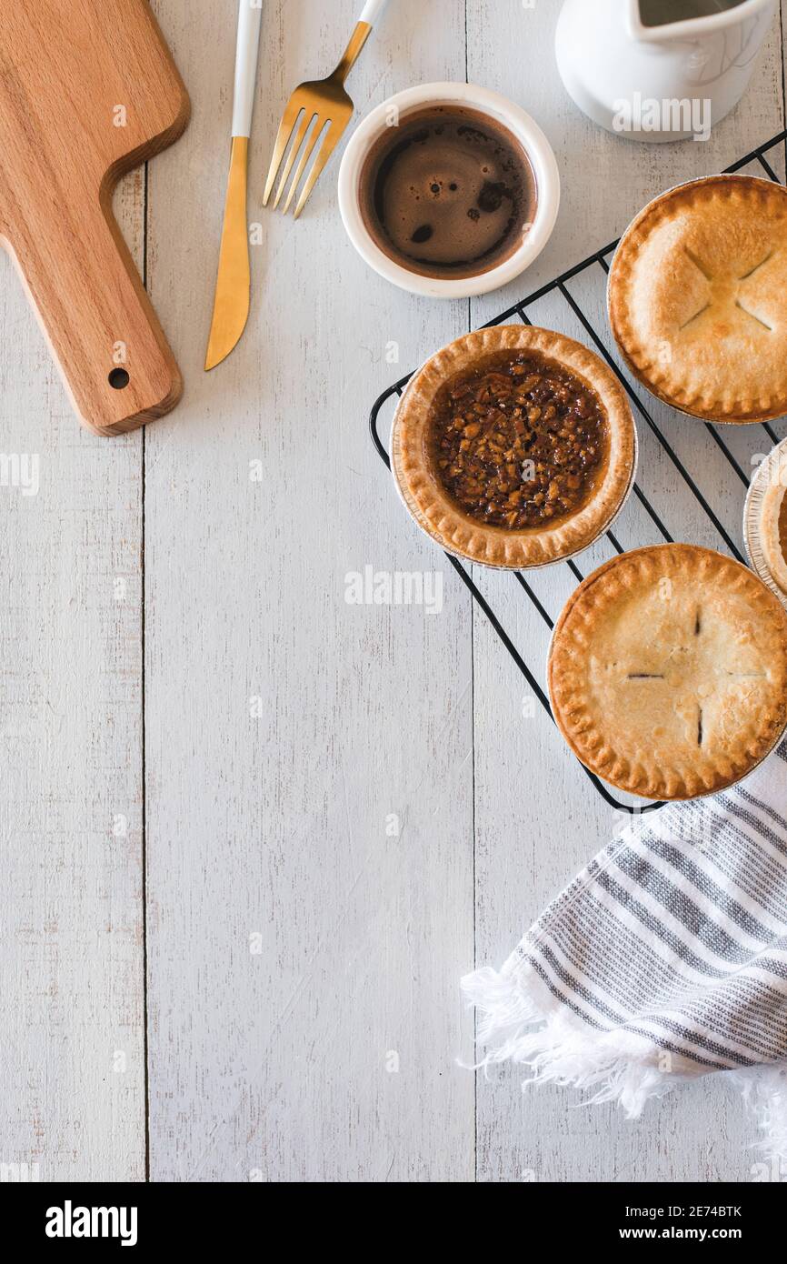 Four mini pies straight from the oven on white wooden table with milk ...