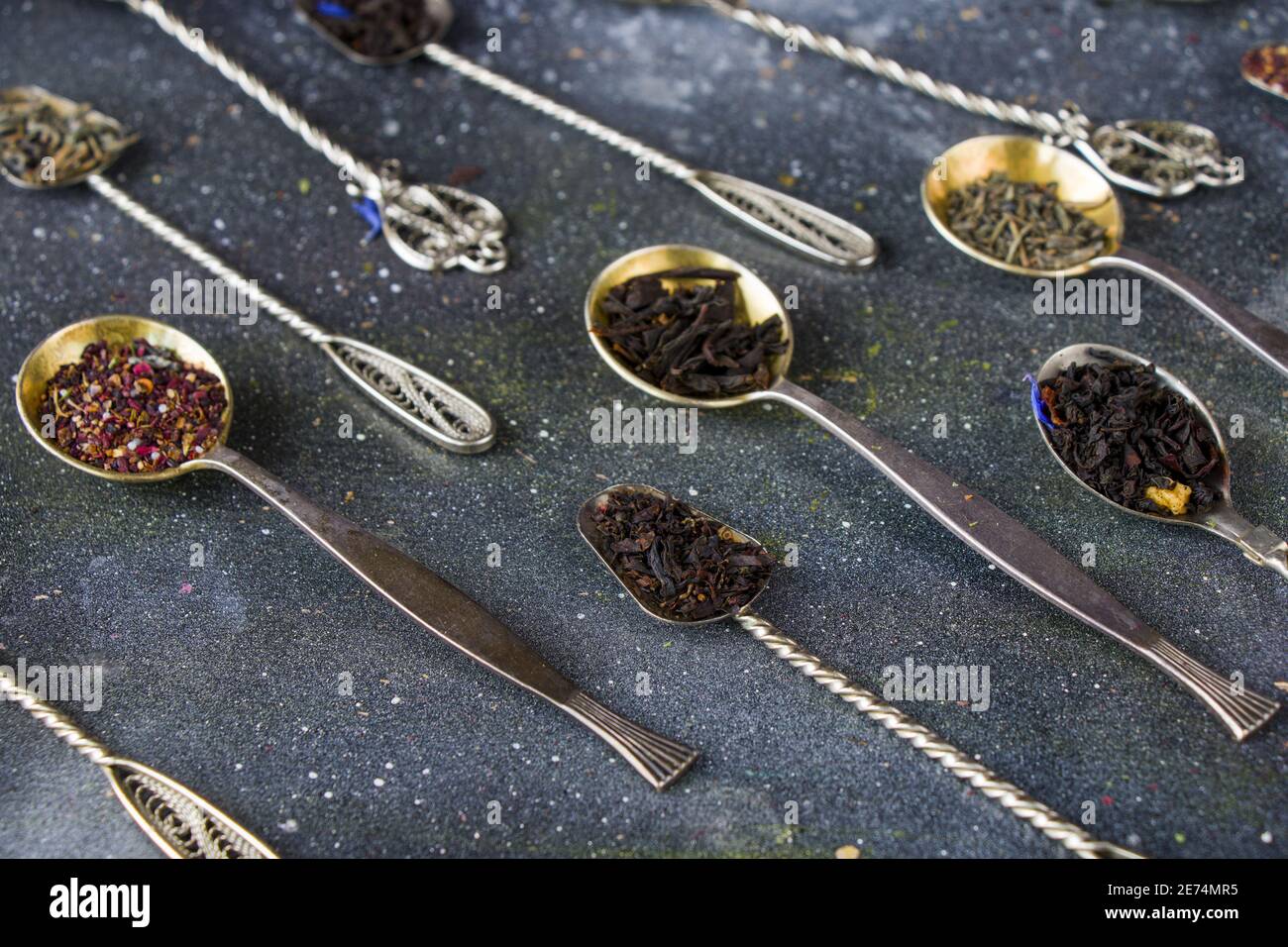 Set of dry tea assortment on vintage silverware spoons neatly arranged on a table surface Stock ...