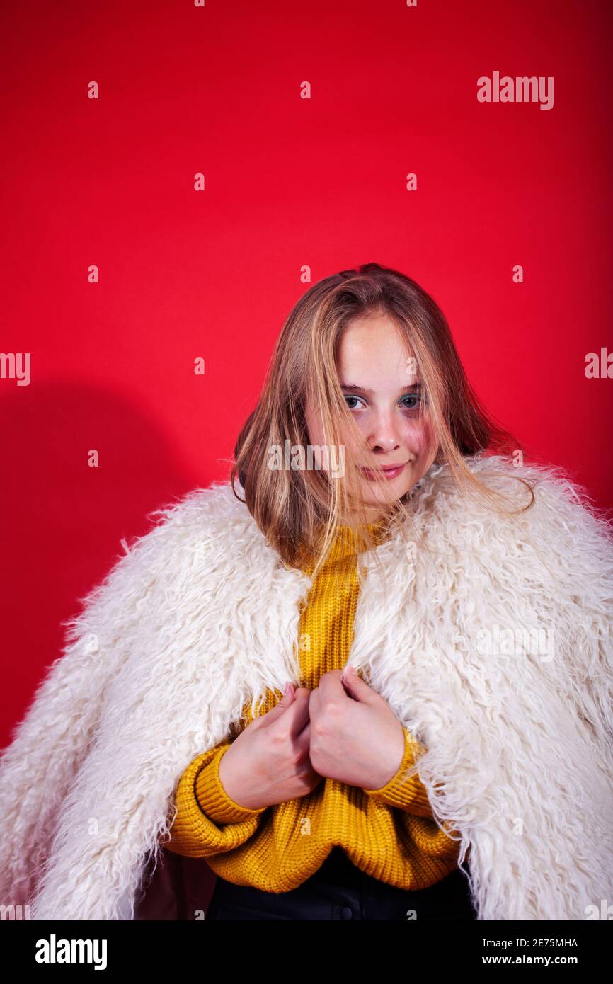 young pretty fashion teenage girl on bright red background, happy ...
