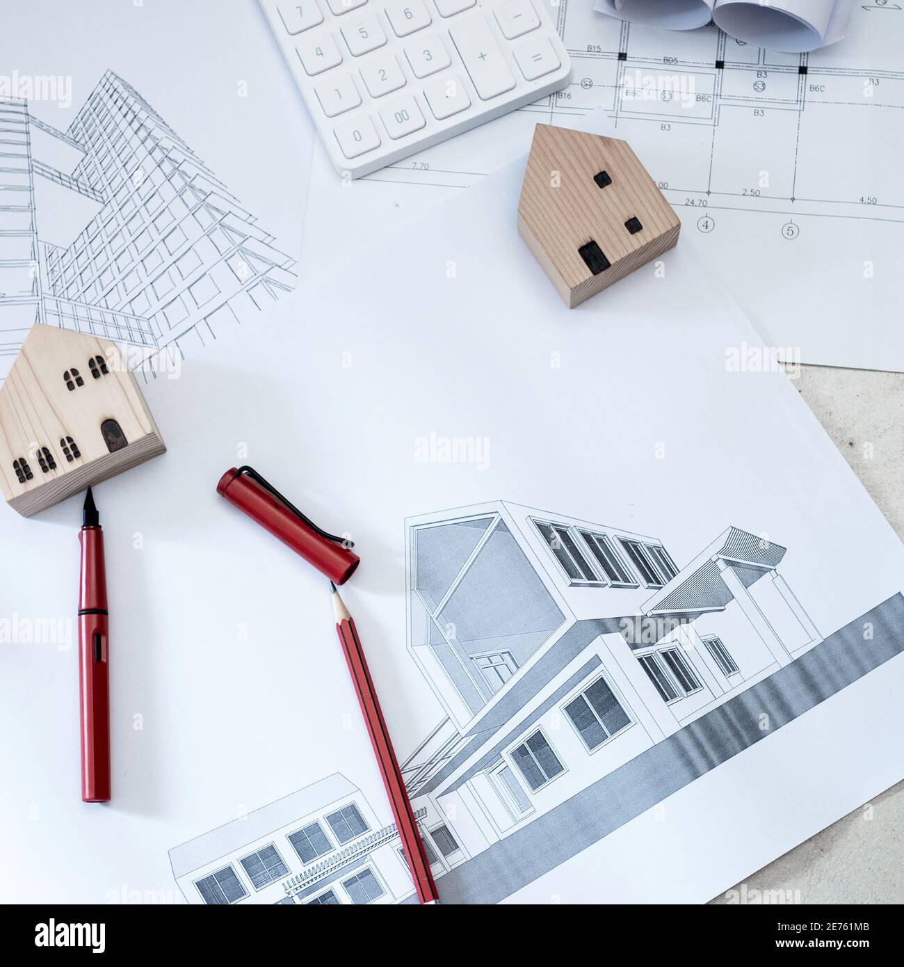 Paper rolls, construction drawings, calculators and wooden house models ...