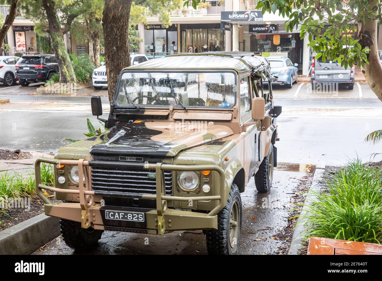 Classic Land Rover Defender 110 in army camouflage colours parked in ...