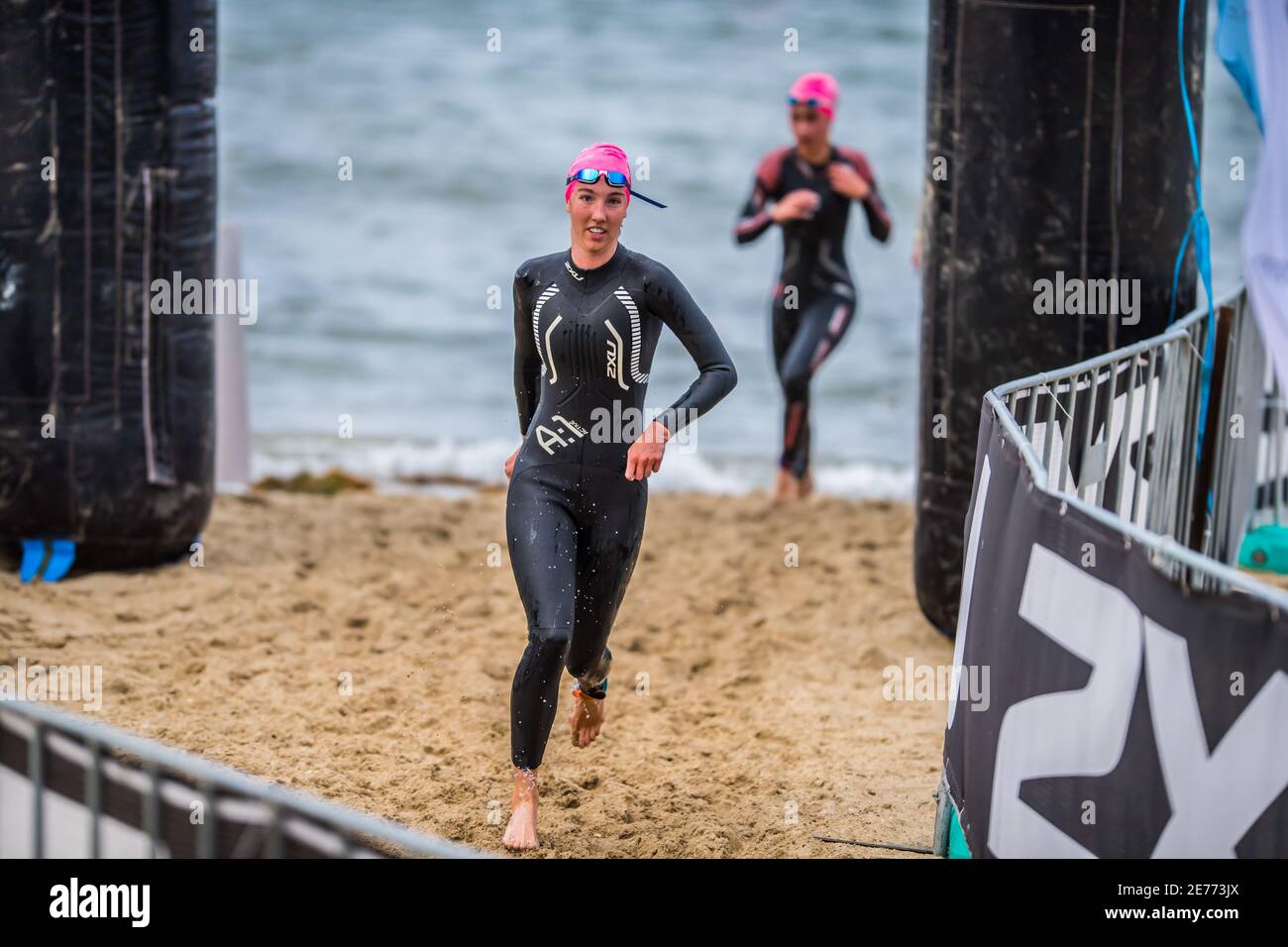 Junior Female Elite, Laura Gillard is running on the sand after a swim ...