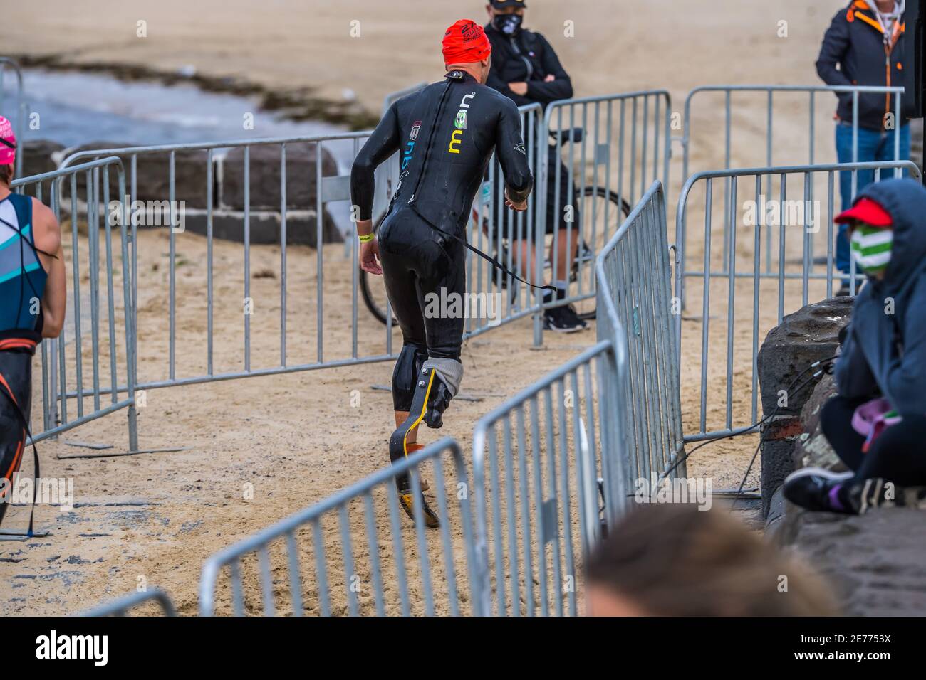 Para triathlete, Liam Twomey running through the beach gap after a swim using a prosthetic leg ...