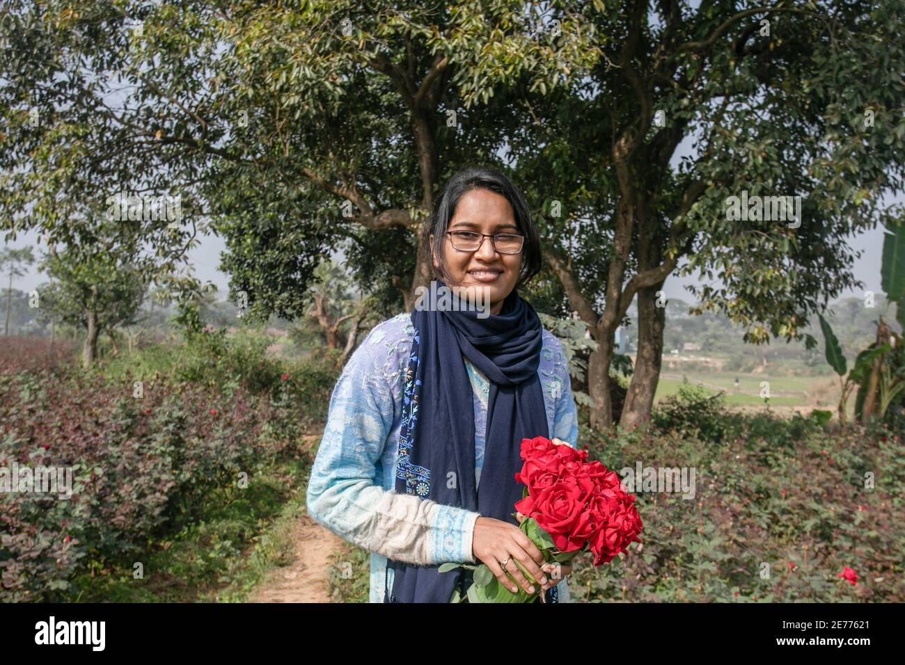 A visitor carries rose flowers in Savar, a small village near Dhaka ...