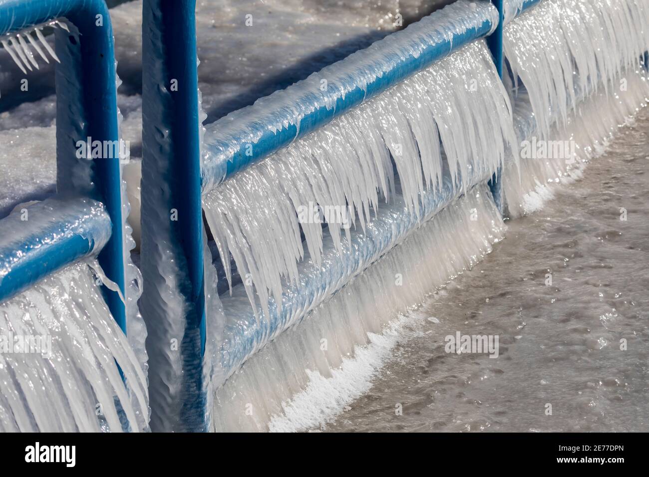 Ice, water and wind at Lake Michigan form icicles on the railing Stock ...