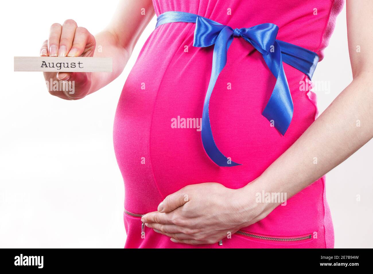 Pregnant woman in pink dress with blue ribbon showing word august ...