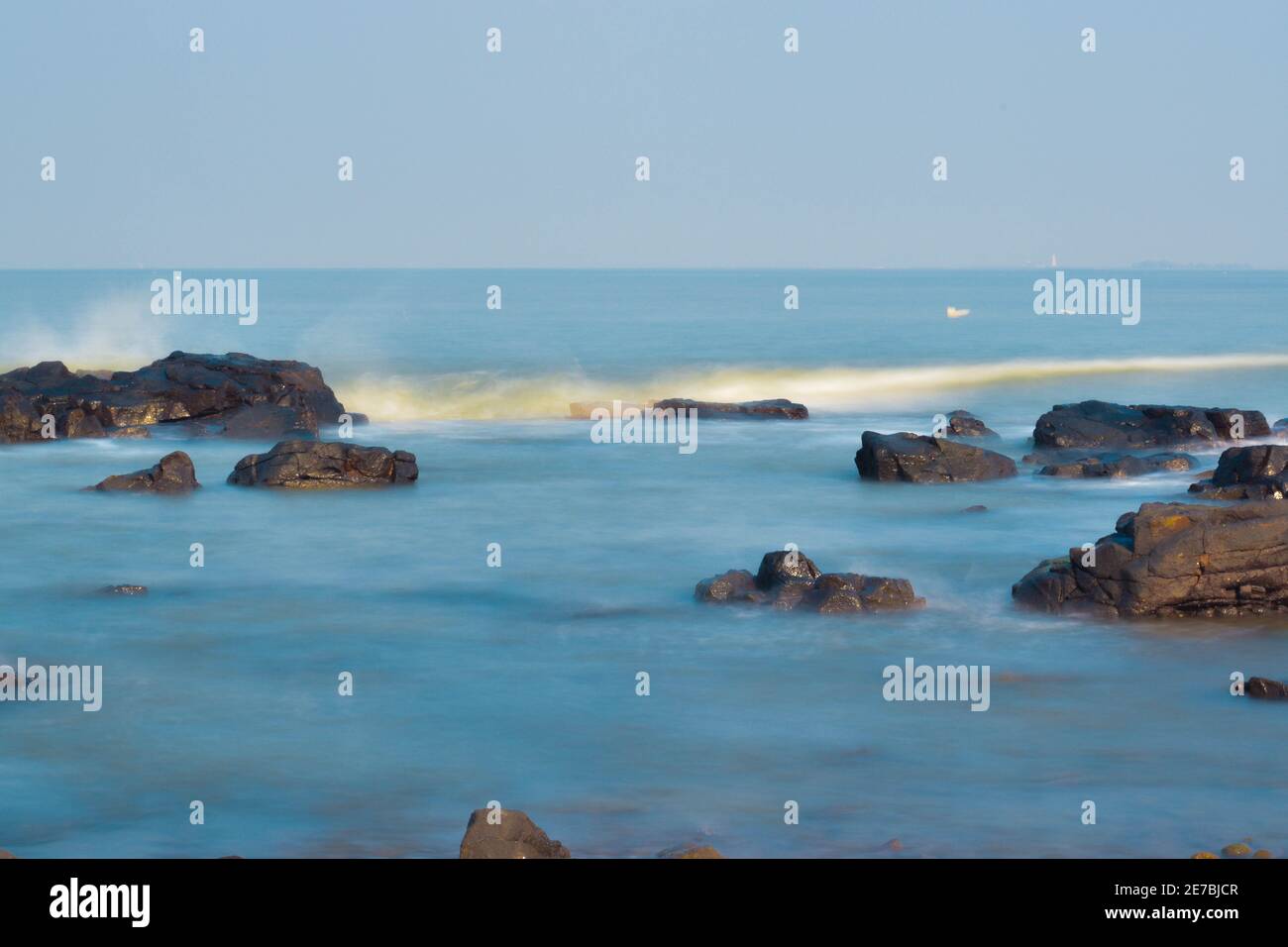 Boulders and stone laying in shallow water Stock Photo - Alamy