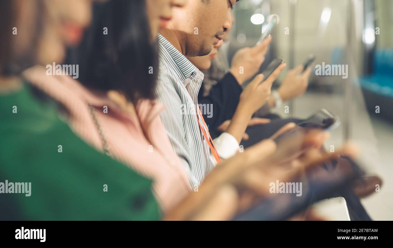 Young people using mobile phone in public underground train . Urban ...