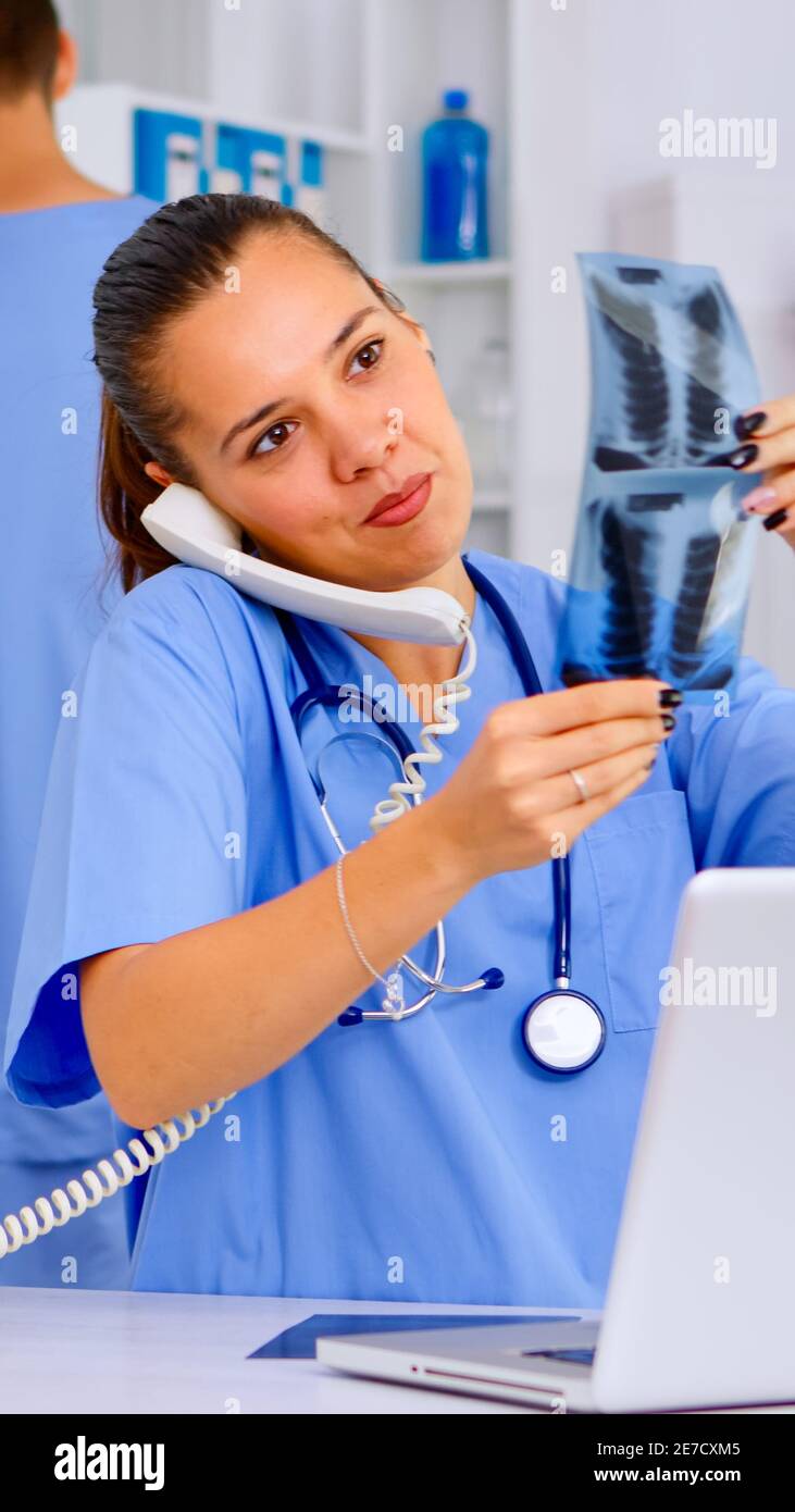 Physician nurse answering patient call by phone, looking at his ...