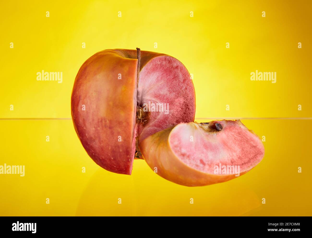 An apple with red flesh inside the cut wedge lies nearby. Yellow ...