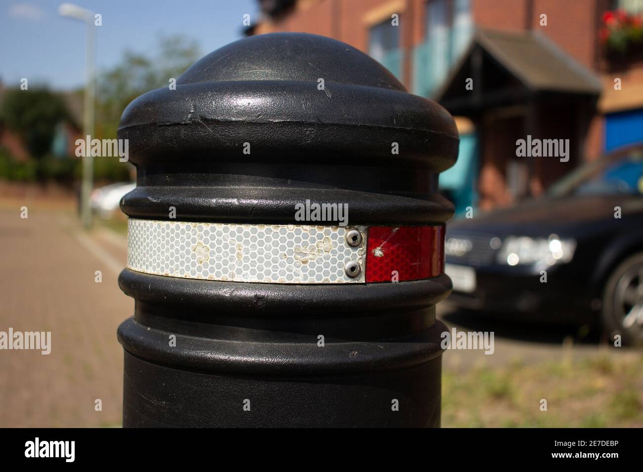 black no entry bollard with red and white reflectors with a car and ...