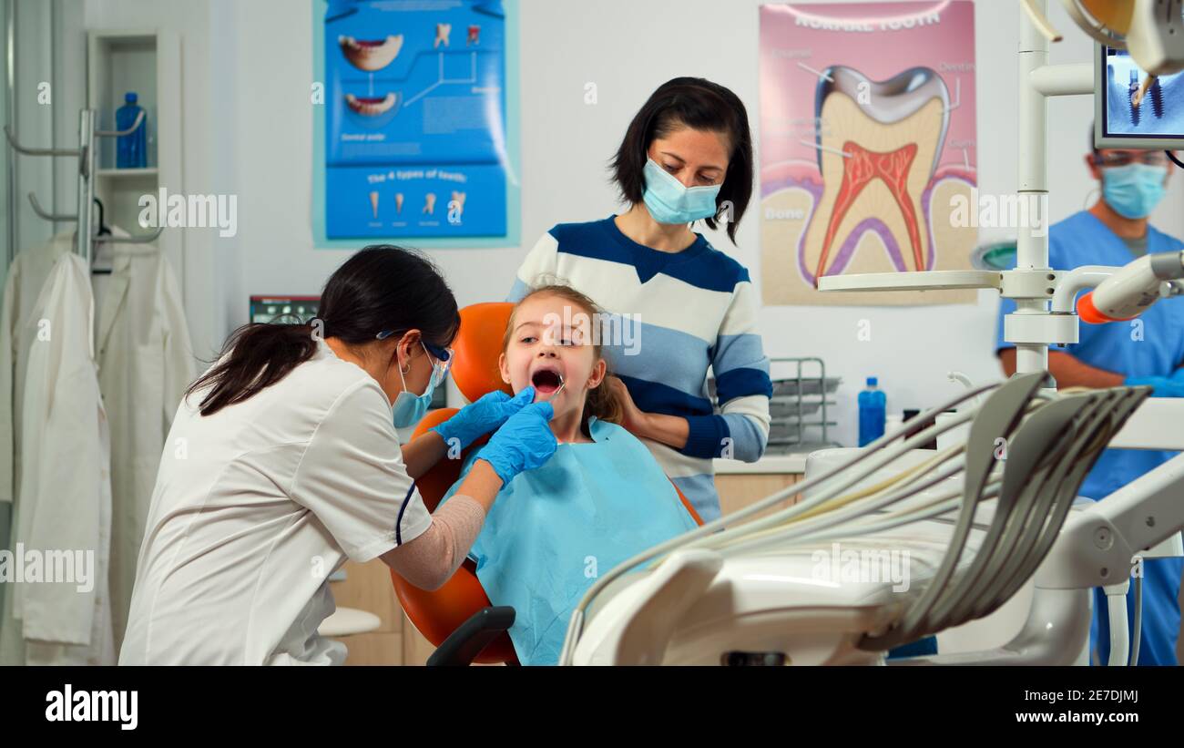 Stomatologist doctor checking tooth health of young patient using ...