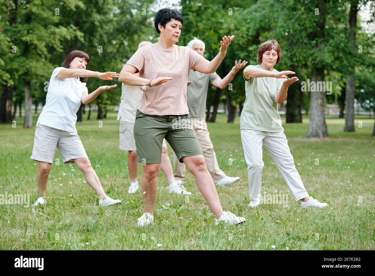 Group of mature people exercising during sports training in the park ...
