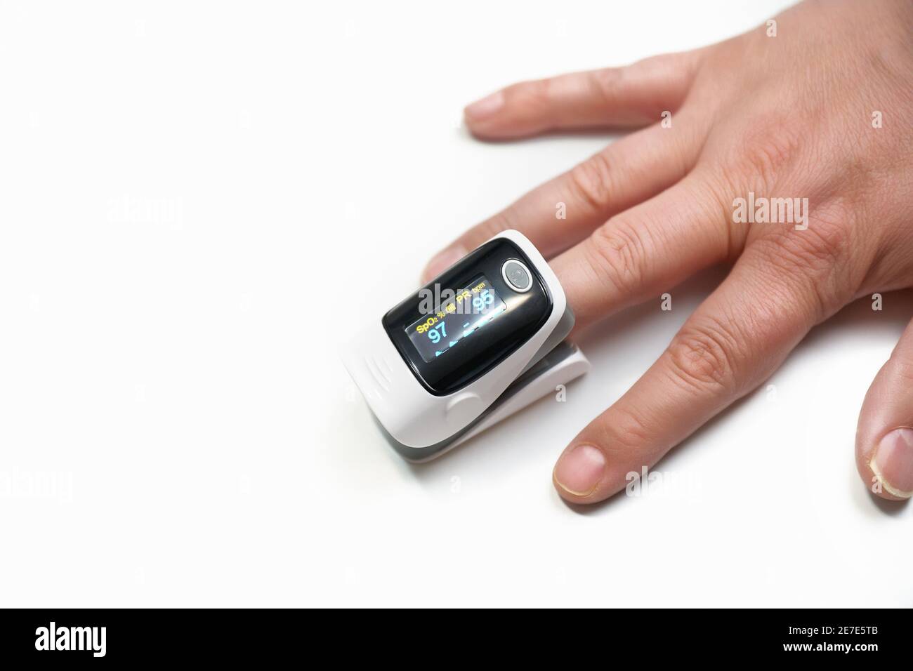 Pulse oximeter on a finger on a white background Stock Photo - Alamy