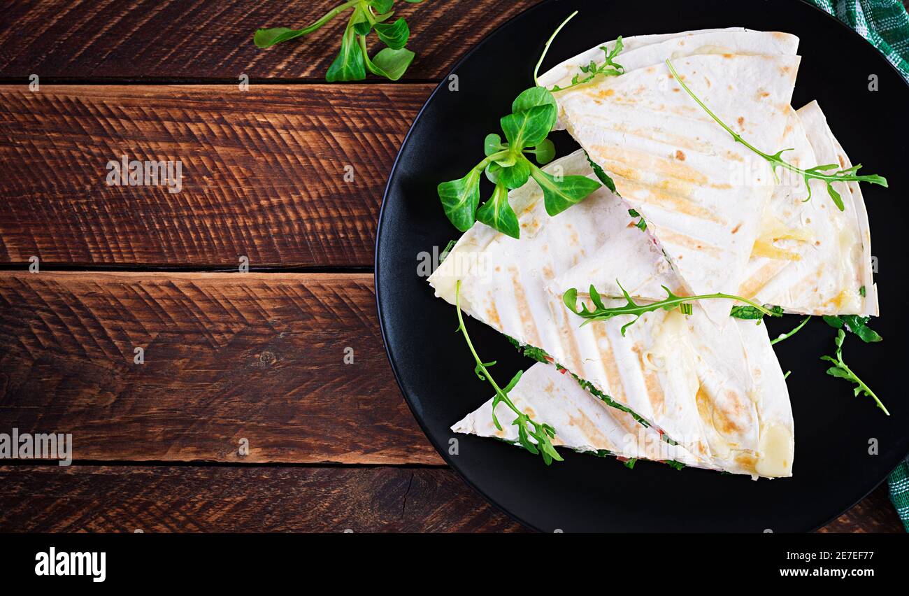 Homemade flatbread with ham, cheese and tomatoes and green herbs ...