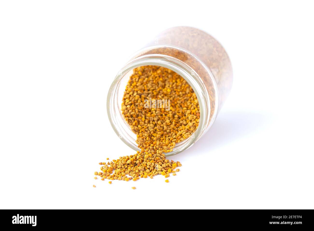 Bee pollen granules crumbled from glass jar n white background. Healthy ...