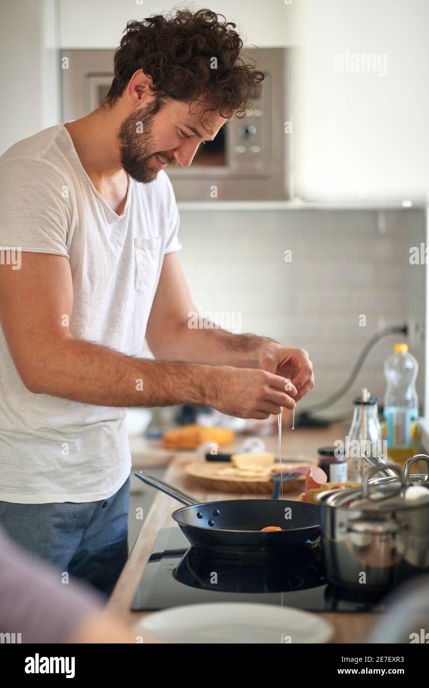 A young guy preparing a meal in the kitchen. Kitchen, food, home ...