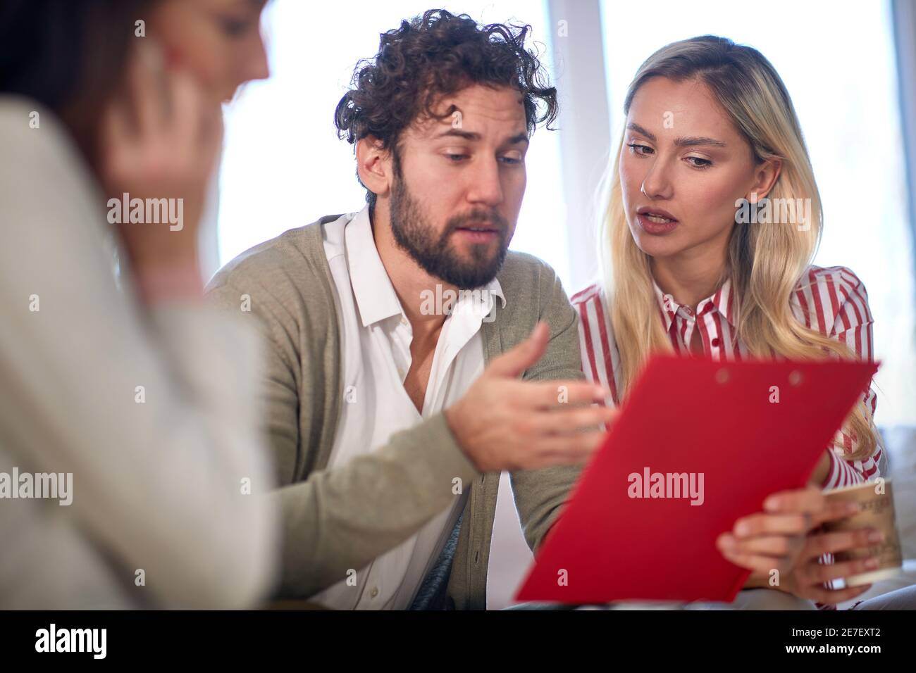 A young businessman at a meeting in a friendly atmosphere explaining ...