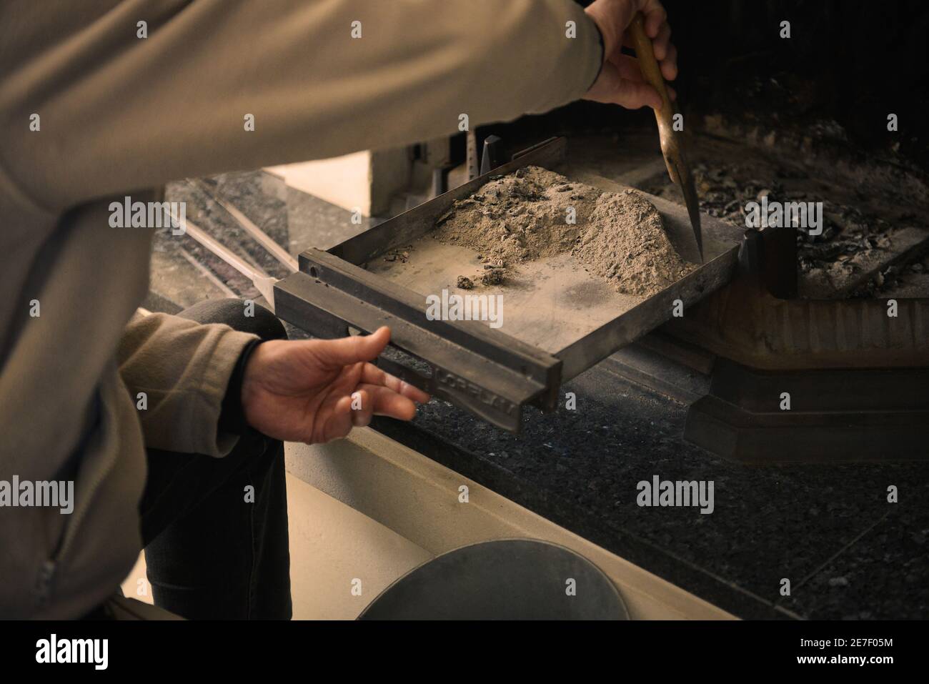 A man cleaning ashes in the fireplace tray Stock Photo - Alamy