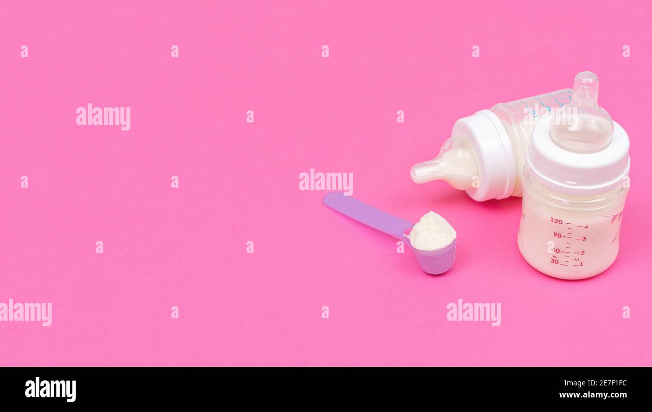 Powder in spoon near baby bottle on white background. Baby food ...