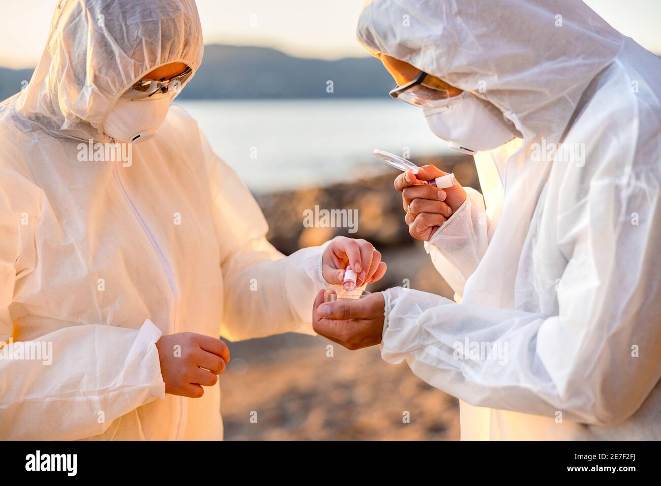 Young multi-ethnic scientists discussing water samples at beach Stock ...