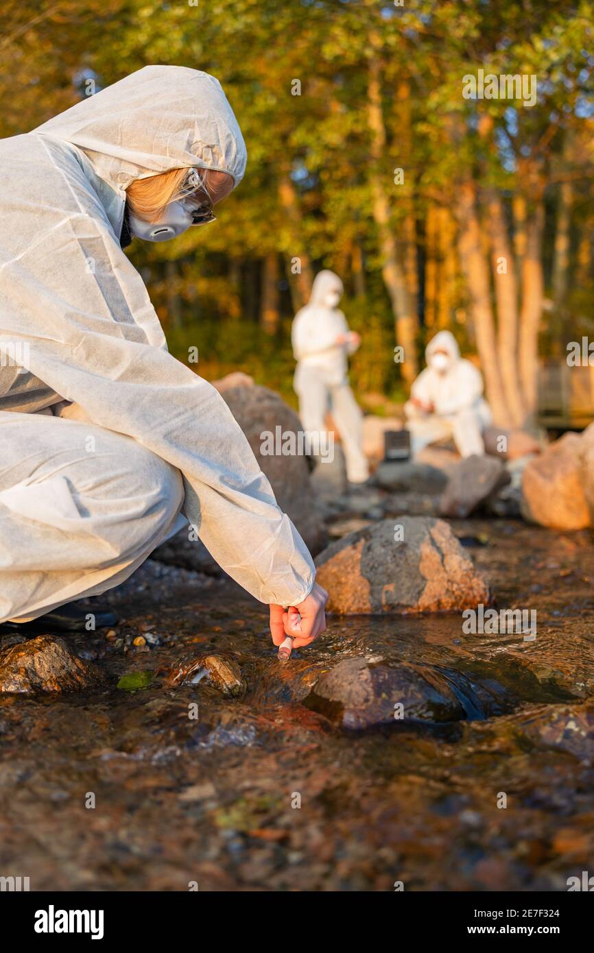 Female scientist collecting water sample from sea with her team Stock ...