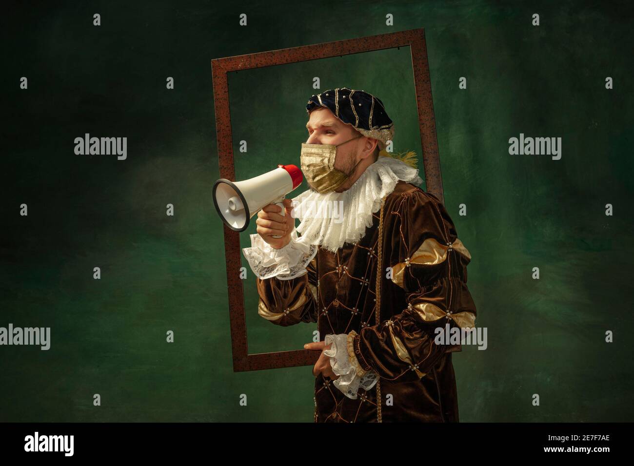 Portrait of medieval young man in vintage clothing, golden face mask ...