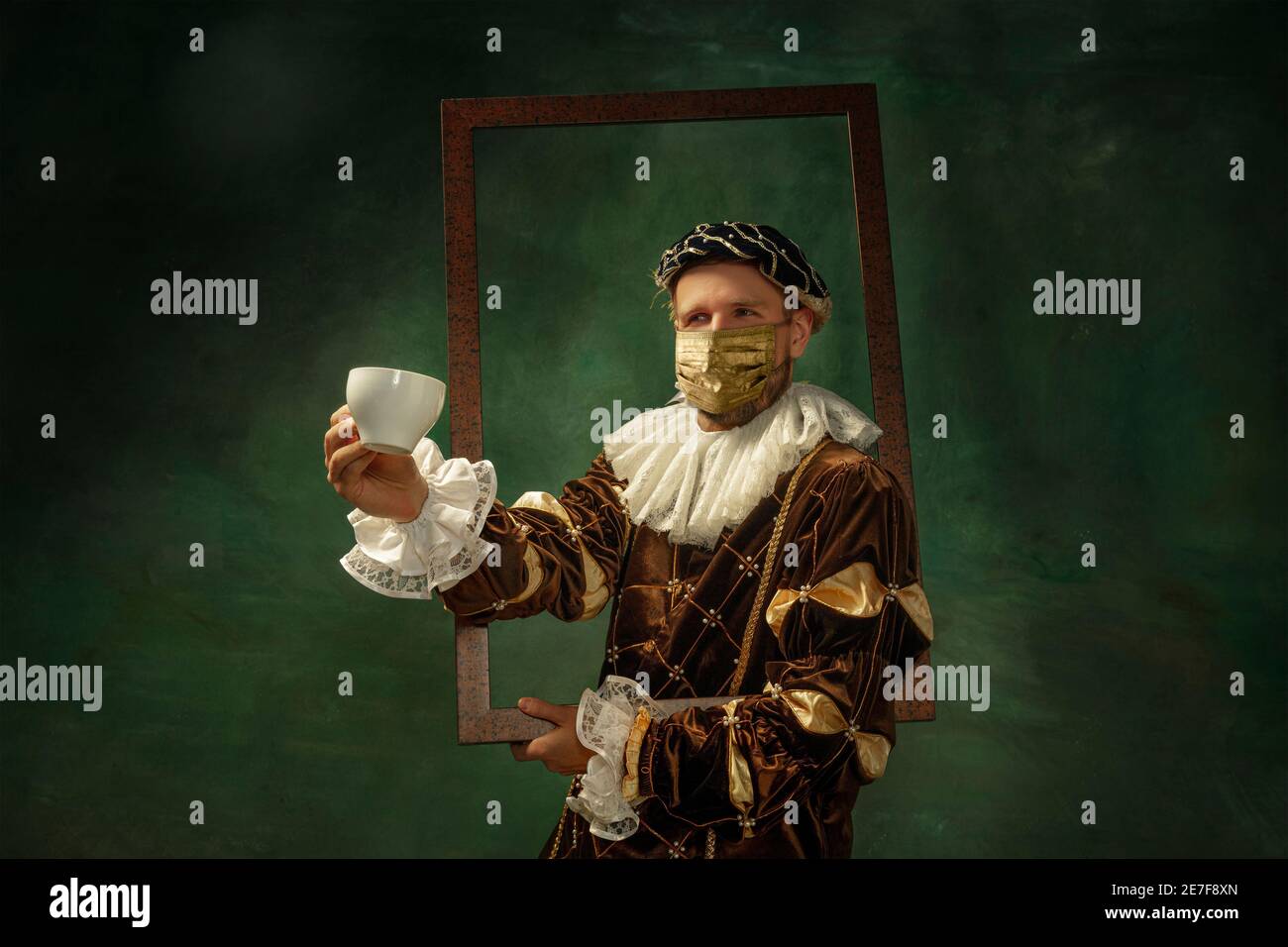 Portrait of medieval young man in vintage clothing, golden face mask ...