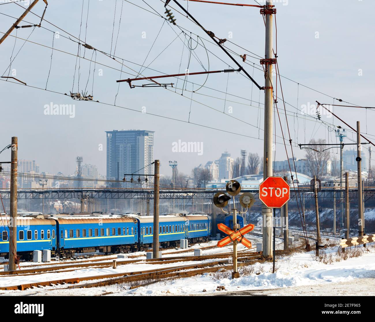 A red stop sign at a railroad crossing against the backdrop of railroad ...