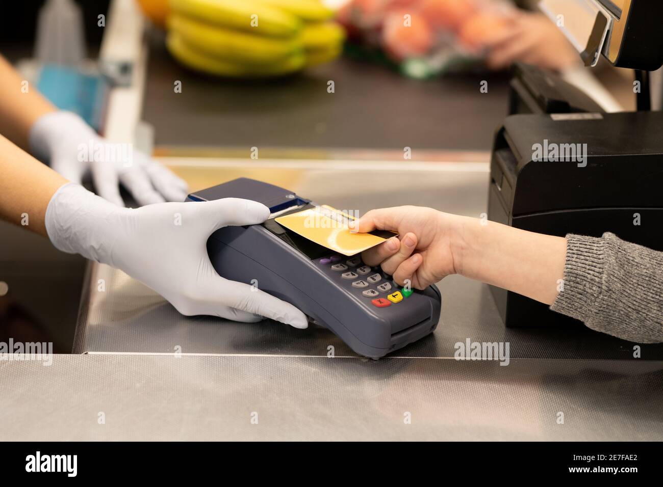 Hand of young female consumer holding credit card over screen of ...