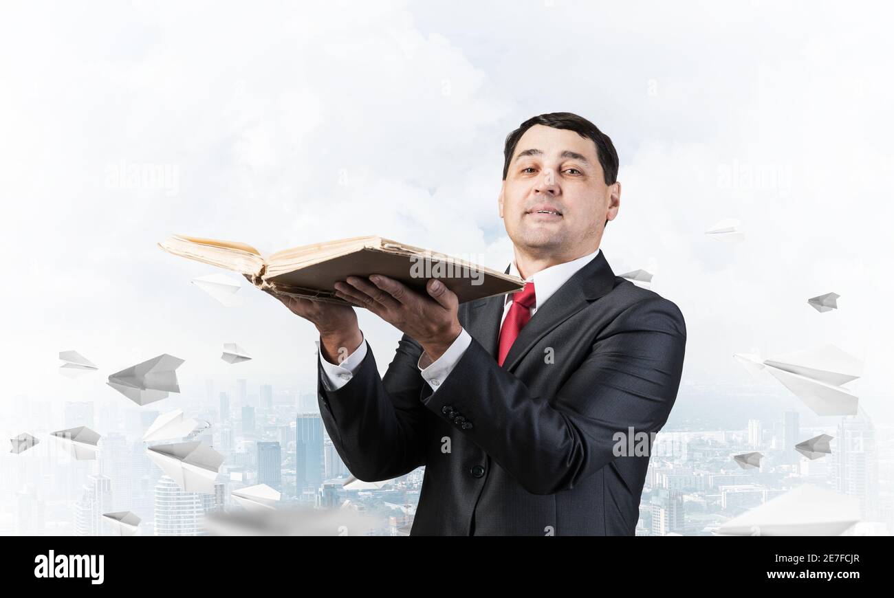 Serious businessman holding open old book Stock Photo - Alamy