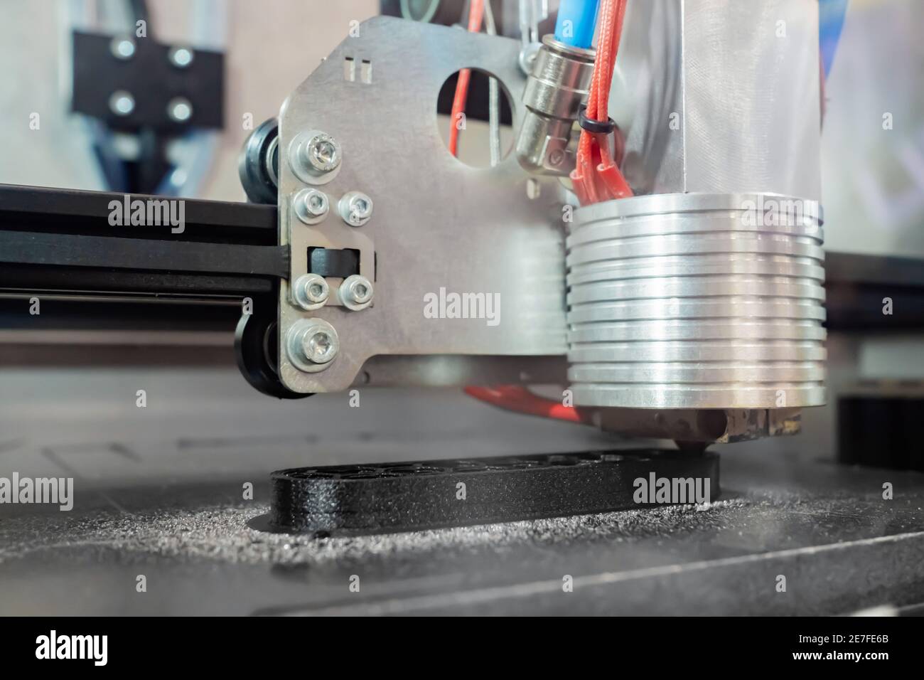 Modern 3D printer machine printing plastic model at trade show - close ...