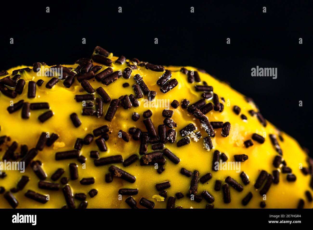 Yellow glazed donut with sprinkles isolated. Close up of colorful donut ...