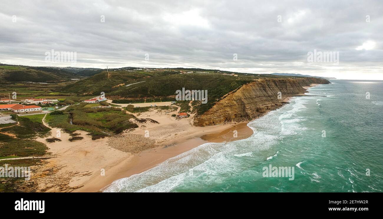 Aerial view of waves on a beautiful sandy ocean beach and cliff ...