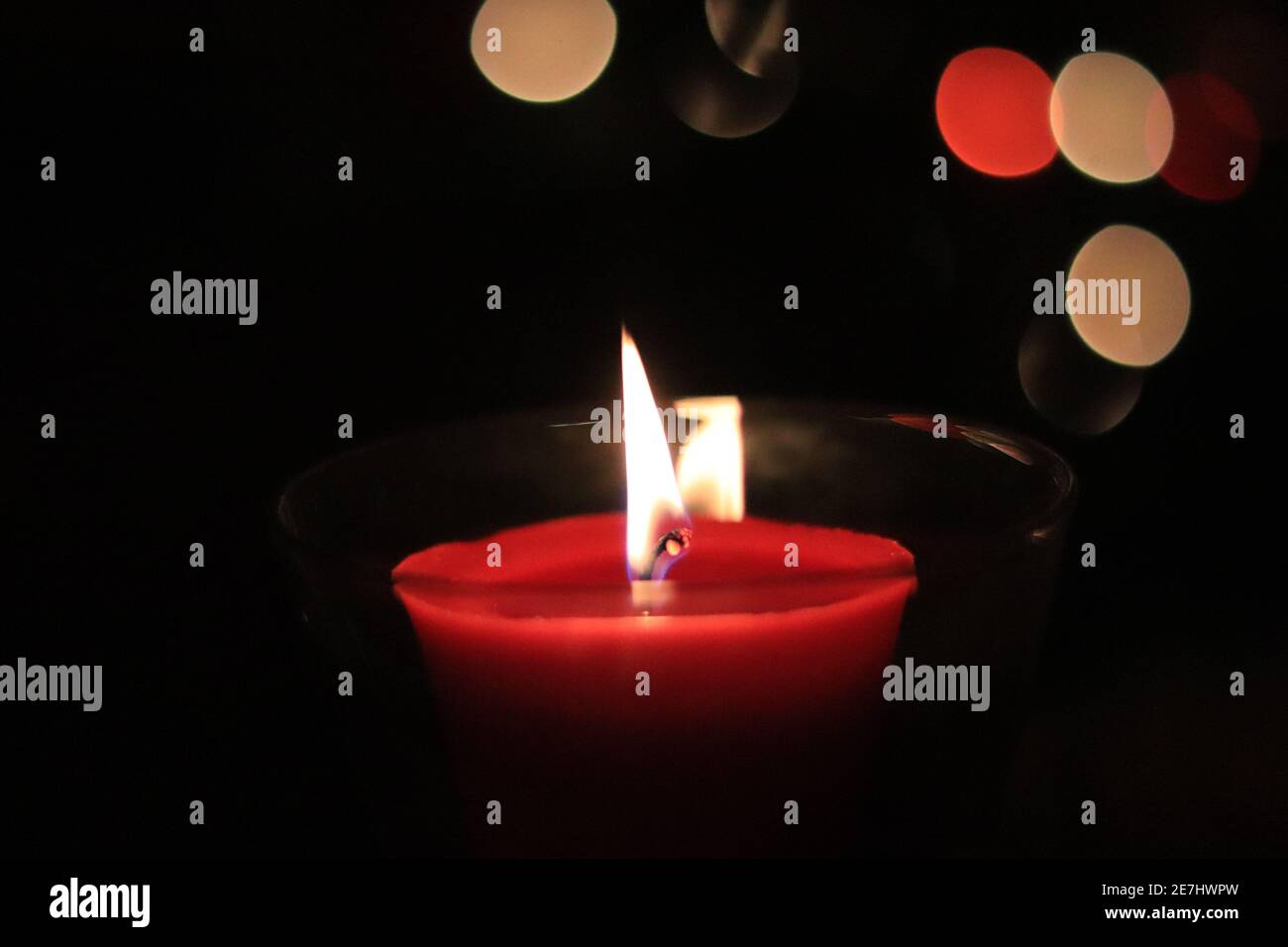 red candle flame at night with lights in background Stock Photo - Alamy