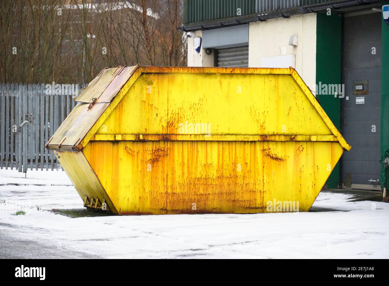 Large yellow skip outside industrial business unit Stock Photo - Alamy