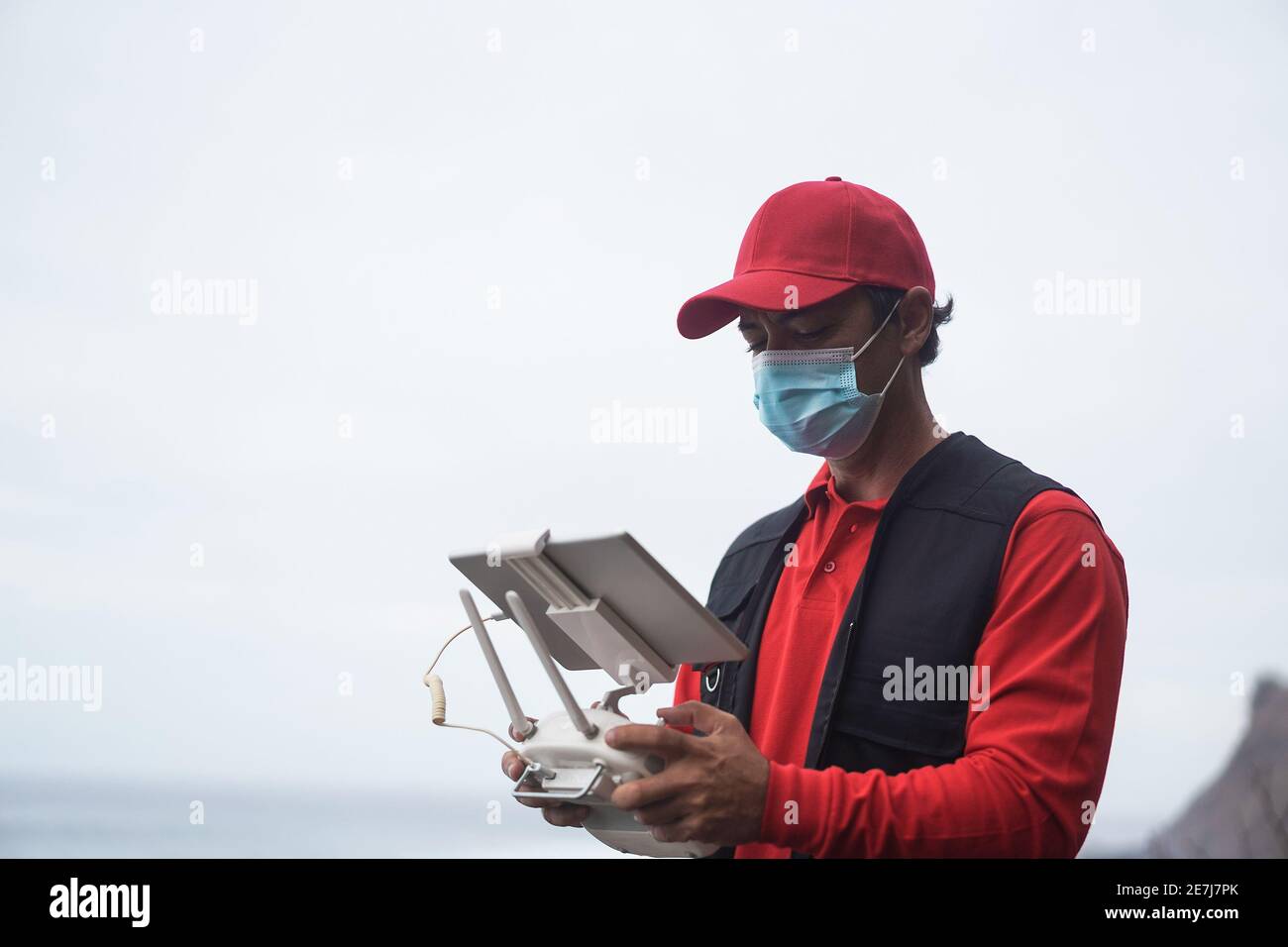 Courier man flying box for delivery with drone while wearing safety ...