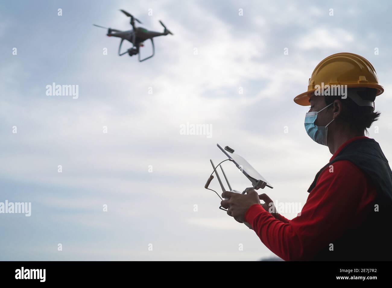 Man engineer flying with drone while wearing safety mask - Focus on ...