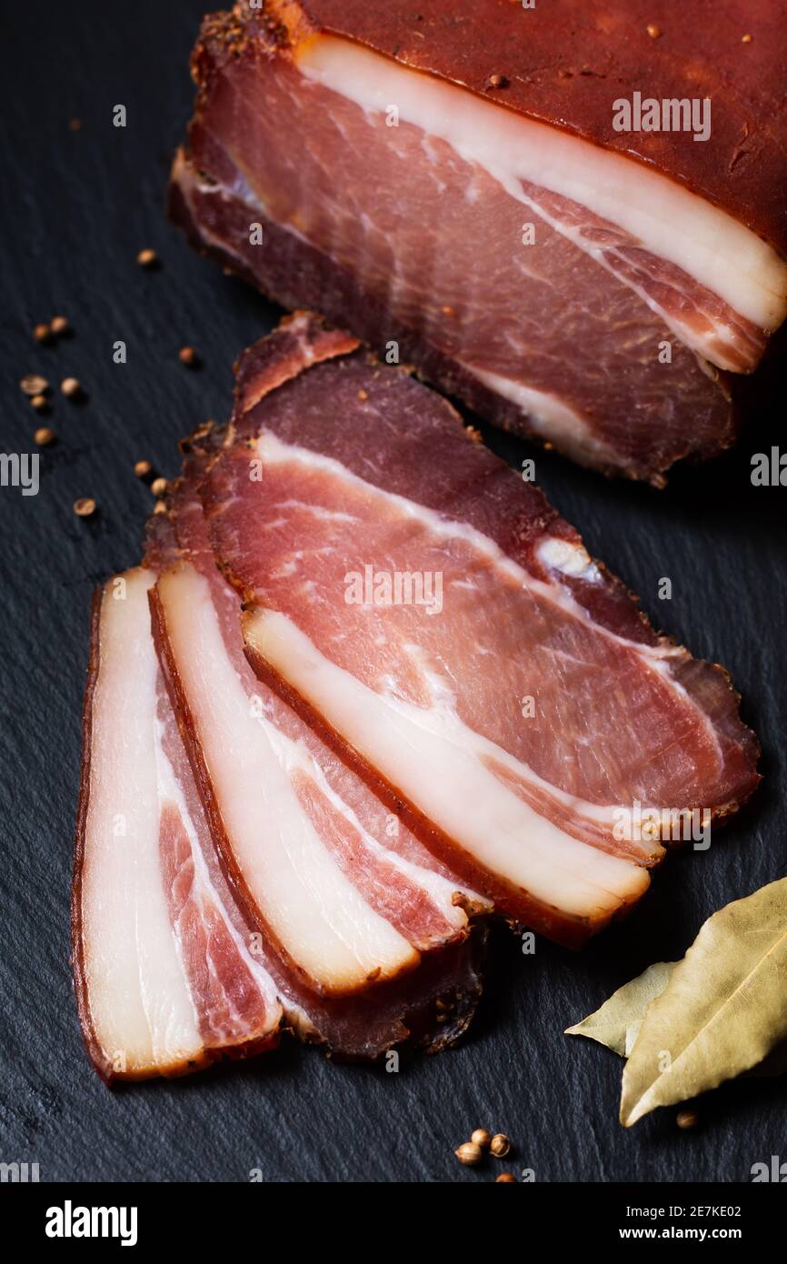 Food concept spot focus Artisan Fresh smoked Bacon on slate stone board ...