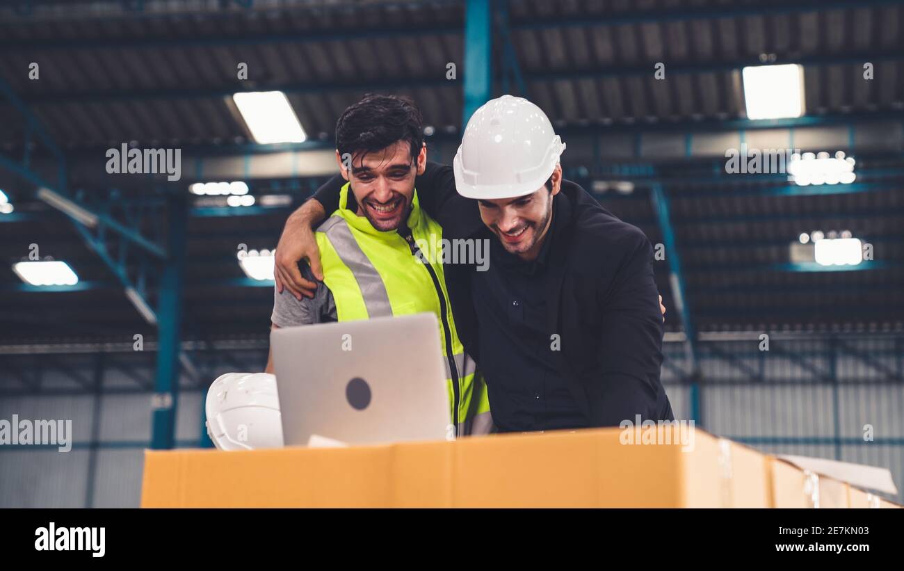 Two factory worker celebrate success together in the factory or ...