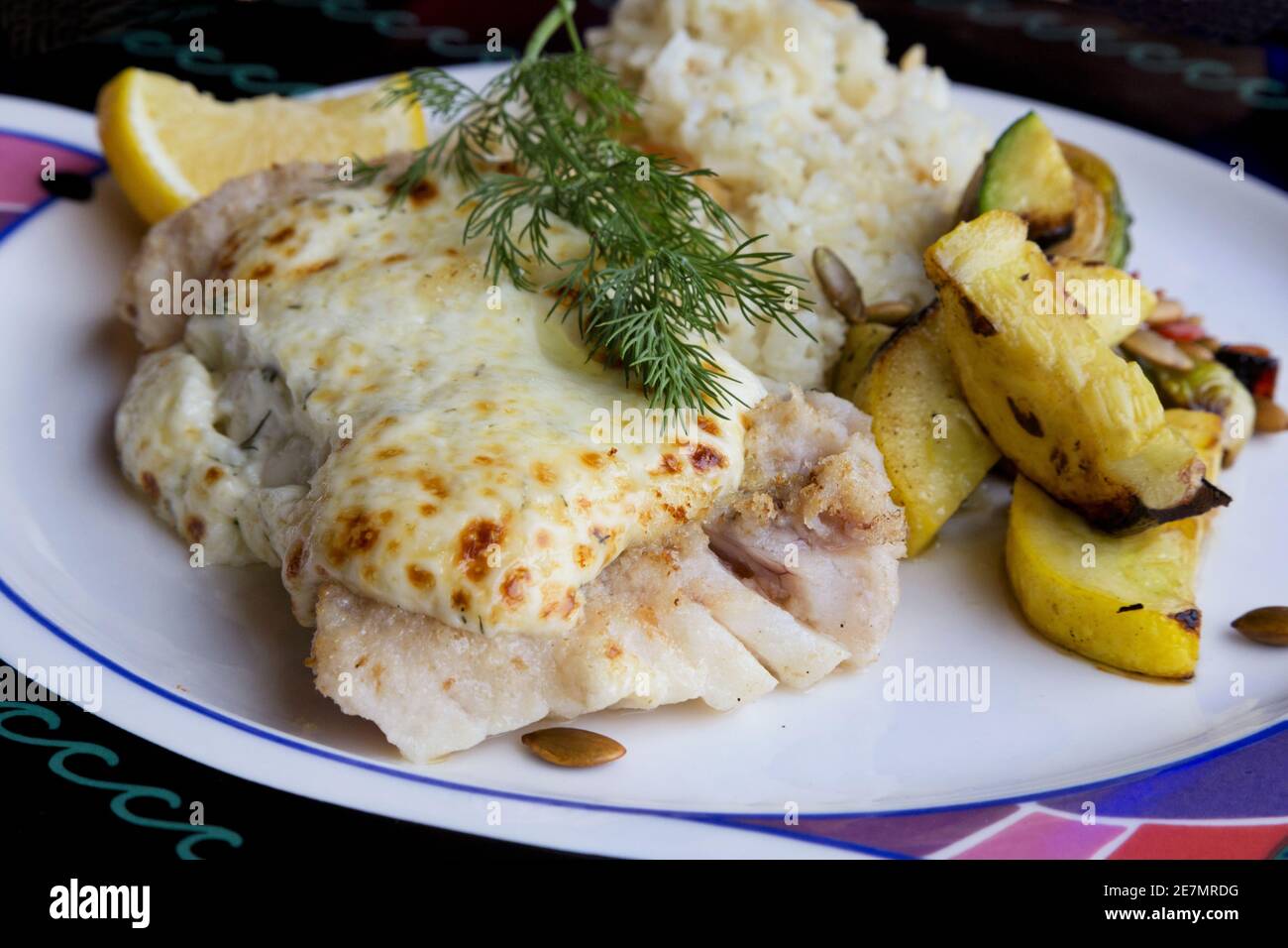 Cod fish with roasted vegetables and rice pilaf dressed with cheese ...