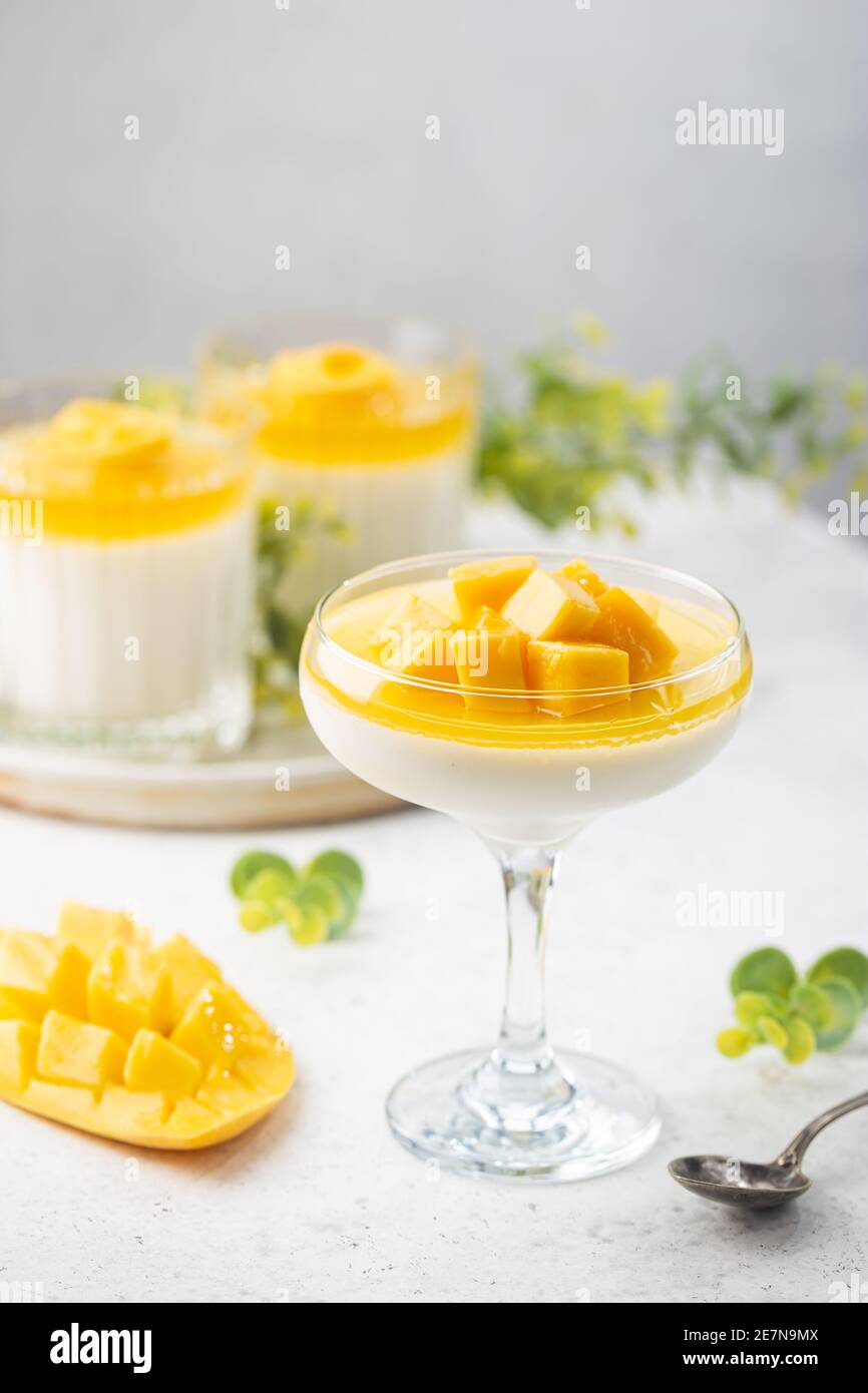 Italian dessert panna cotta with mango in glass on white background ...